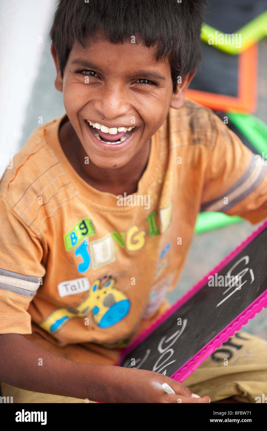 Laughing Indian schoolboy writing english on a chalkboard. India Stock ...