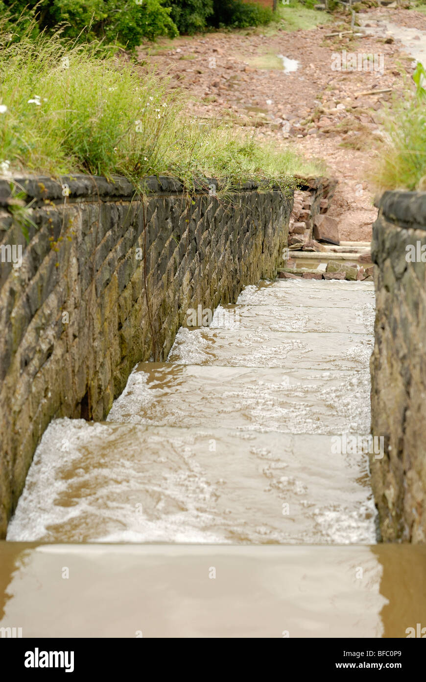 Dam spillway overflow with water running down Stock Photo - Alamy