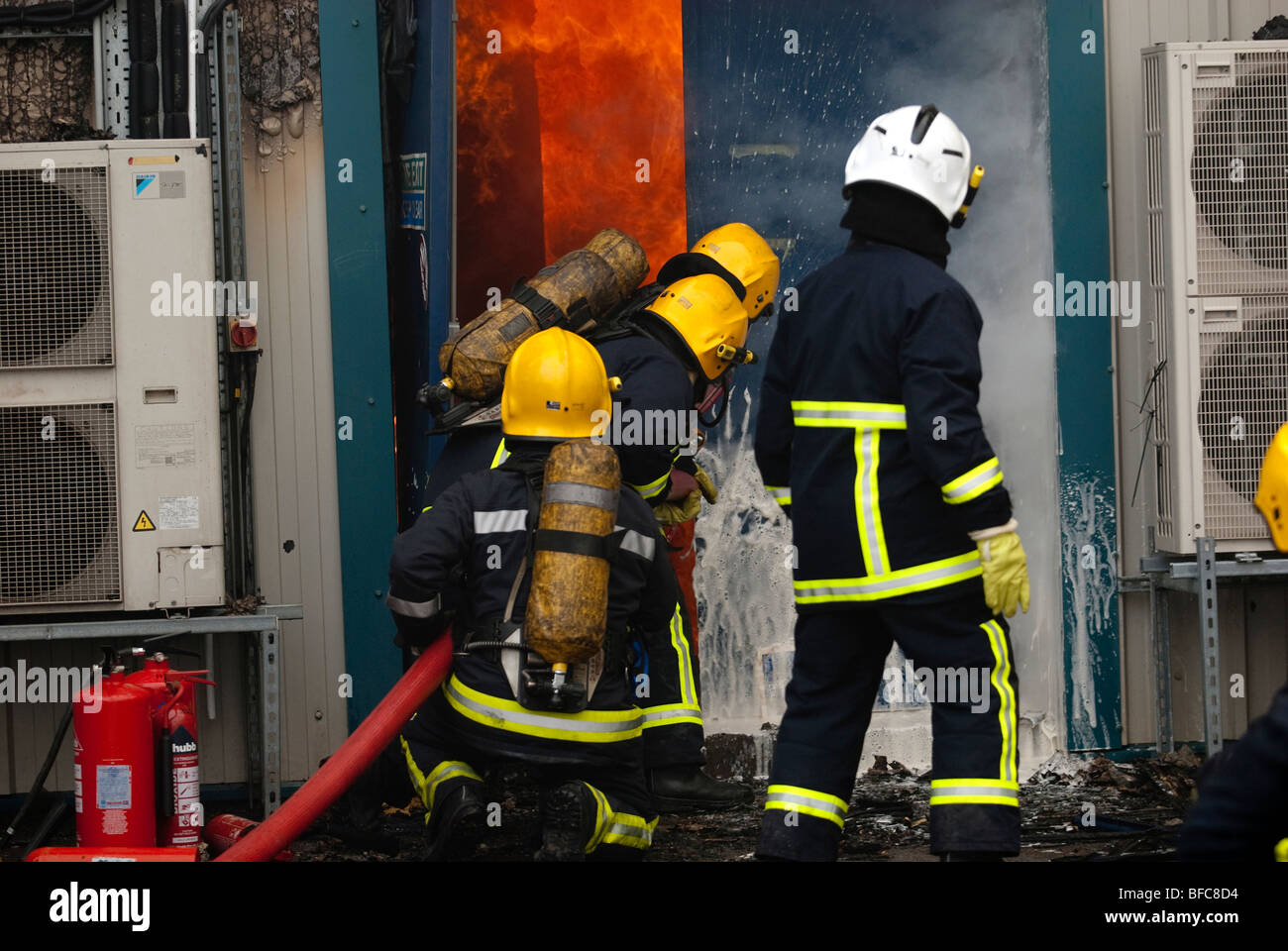 Three firemen in BA enter burning office through fire exit Stock Photo ...