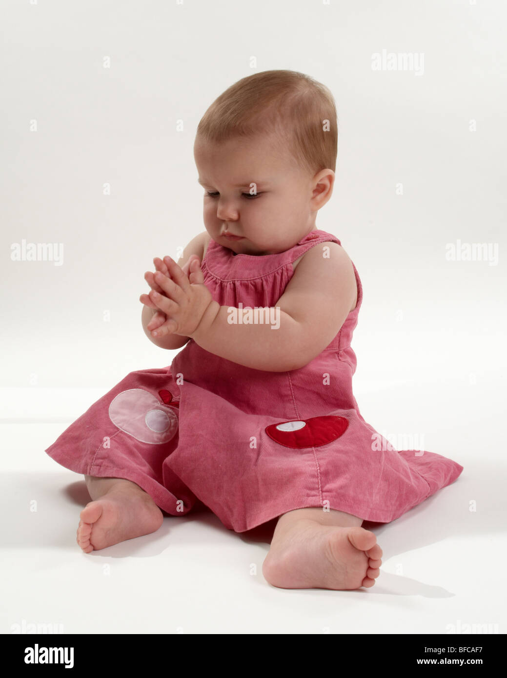 12 month old baby girl playing on floor in pink Stock Photo - Alamy