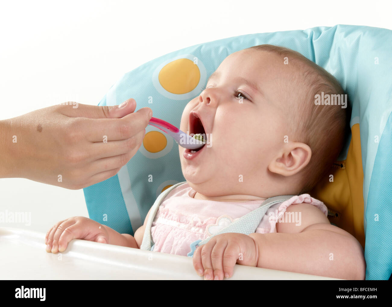 Baby Girl in pink top feeding and being fed in blue and yellow high ...
