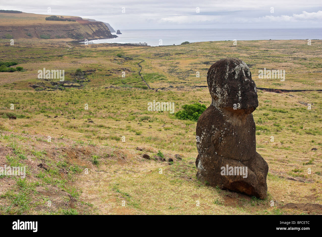 Moai Tukuturi with ahu Tongariki in the background, Rano Raraku Volcano ...
