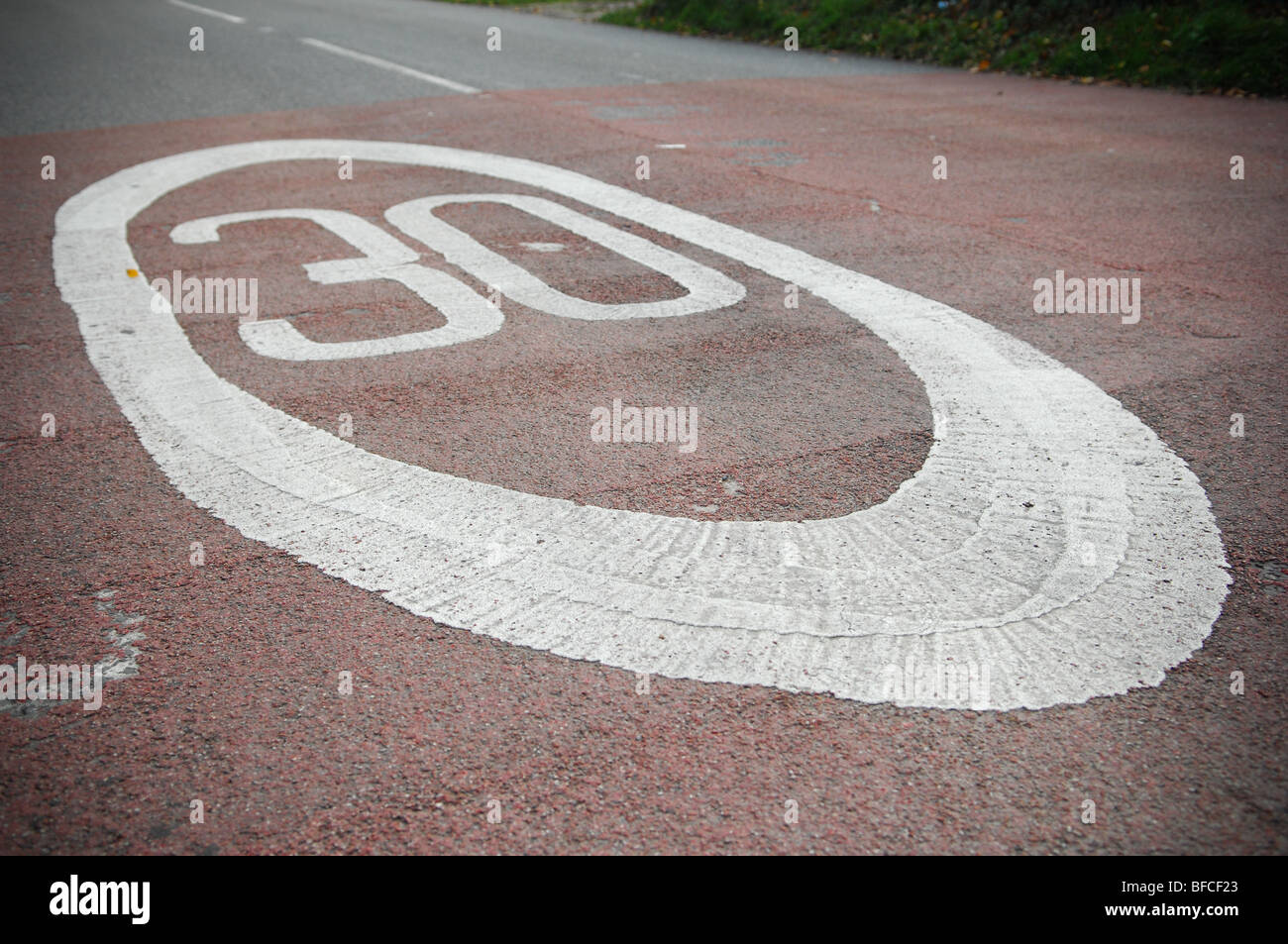 A thirty mile an hour speed limit sign is painted on a minor road in ...