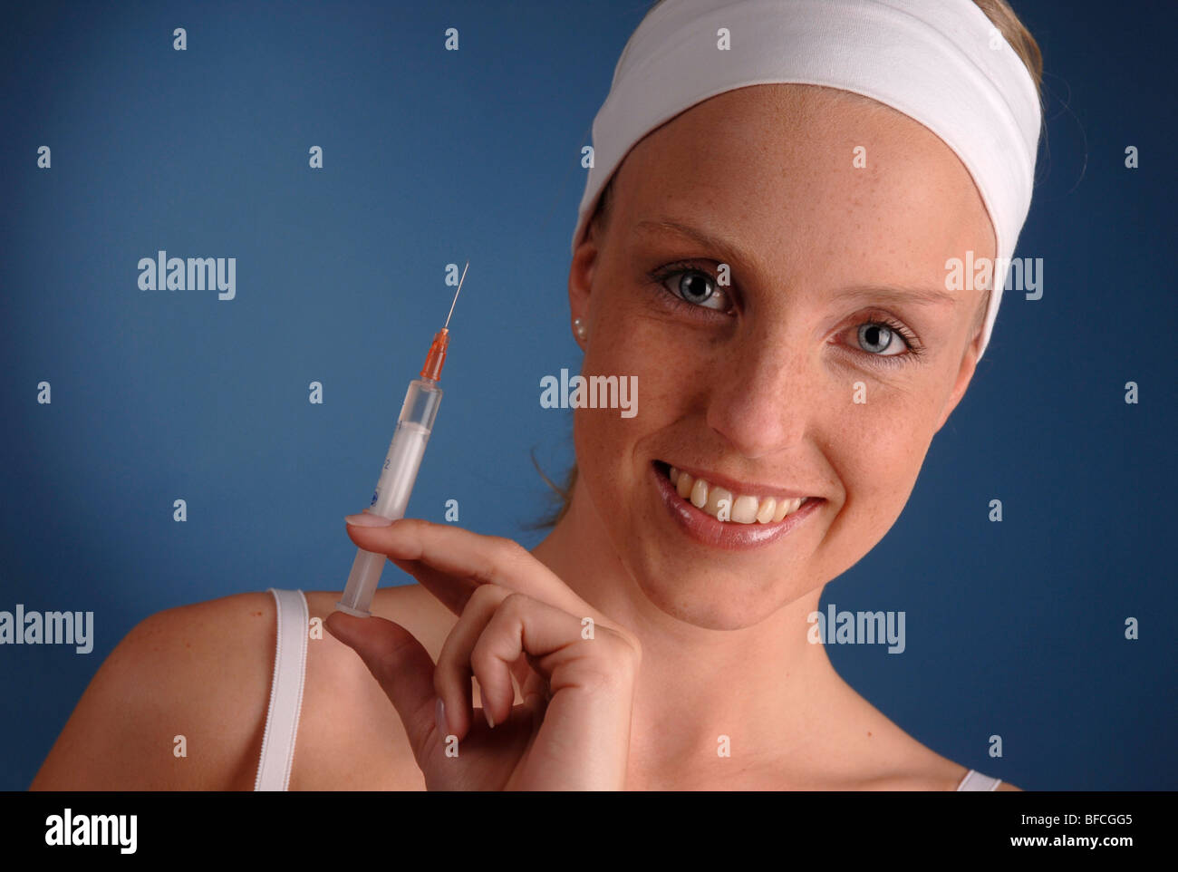 Young woman holding a syringe in her hand Stock Photo - Alamy