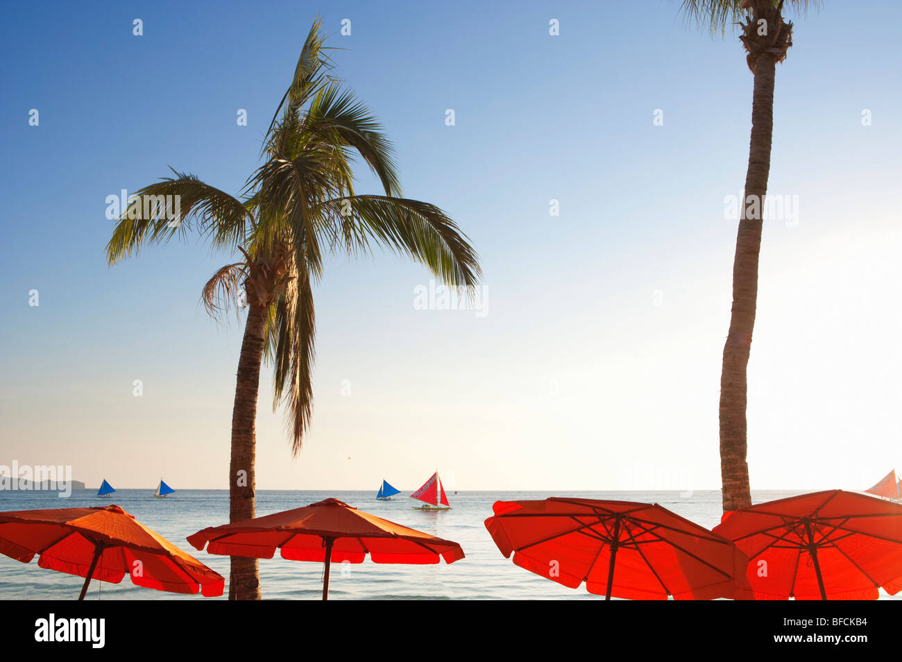 Red parasols and sail boats Boracay; The Visayas; Philippines Stock ...