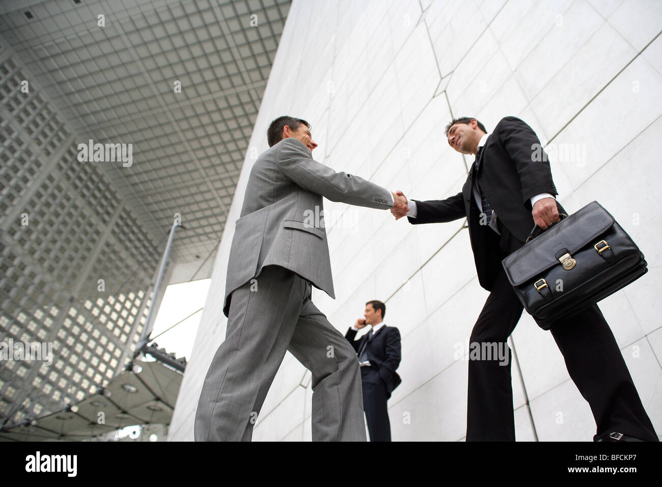 Businessmen shaking hands outside Stock Photo - Alamy