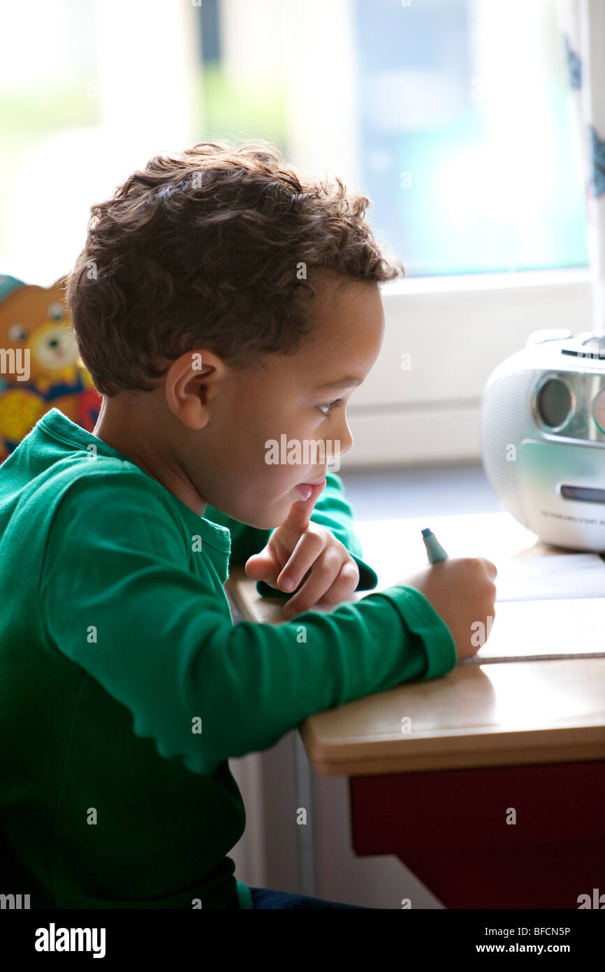 Seven year old boy is thinking how to write Stock Photo - Alamy