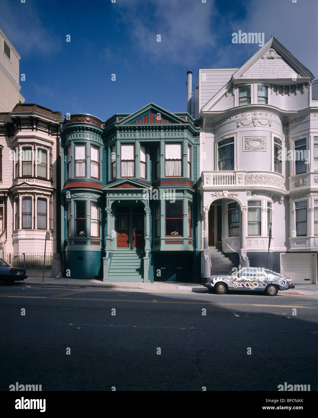 Traditional green double-fronted house with bow windows in terraced row ...