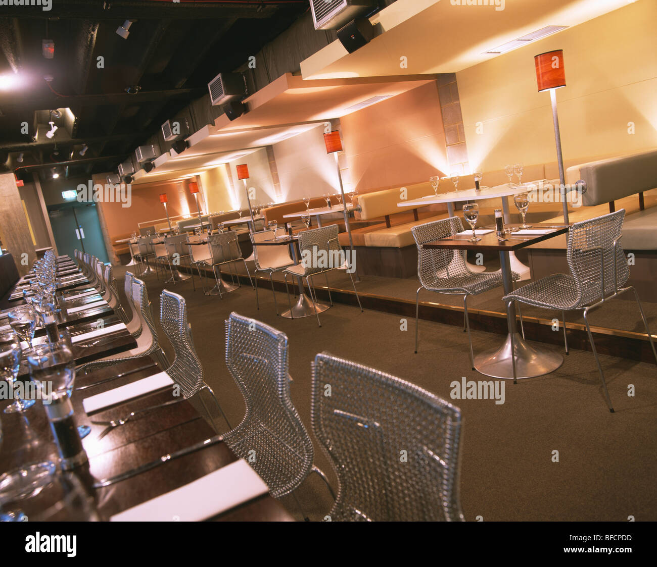 Metal mesh seating in large modern restaurant with red lamps and up ...