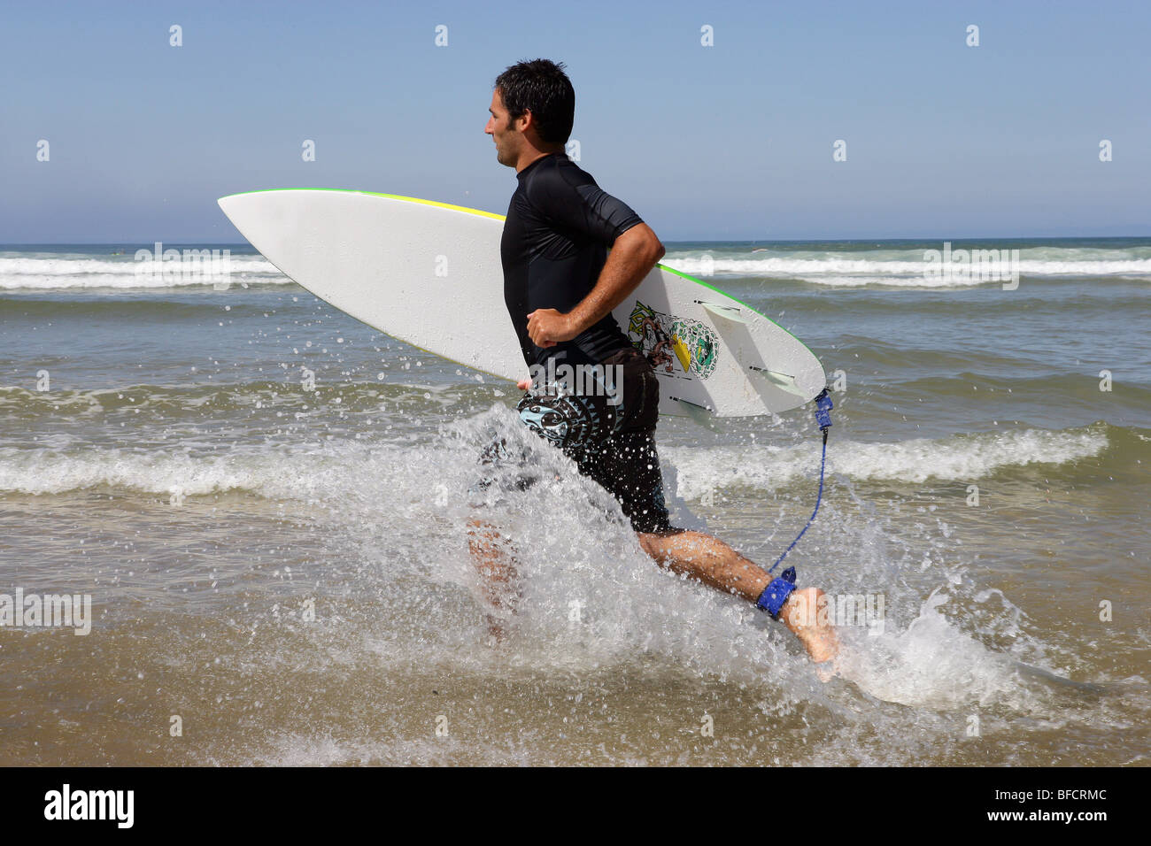 Surfer running with board Stock Photo - Alamy