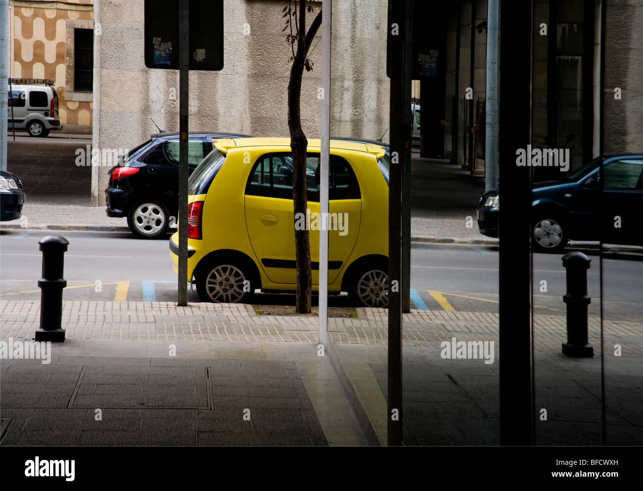 Using the reflection in the glass of a building this car appears very ...