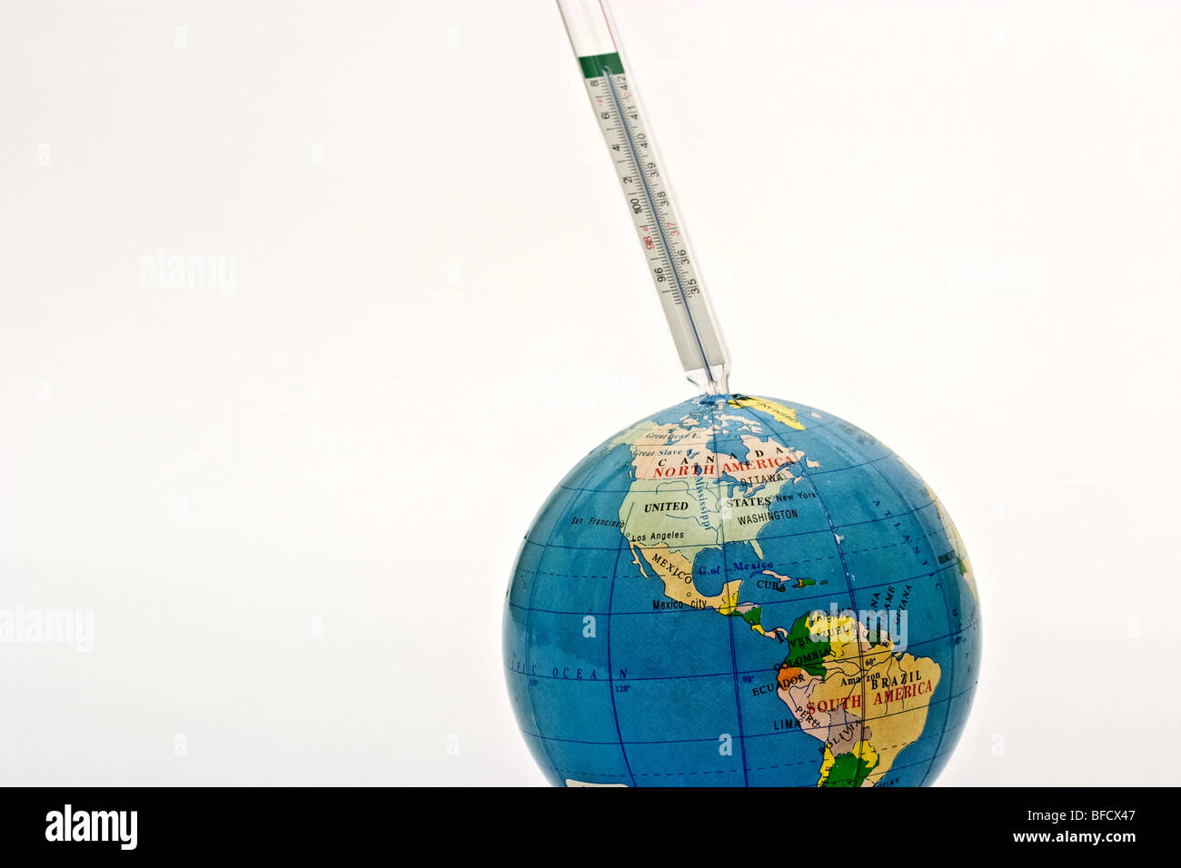 Thermometer at the top of a small globe of the world Stock Photo - Alamy