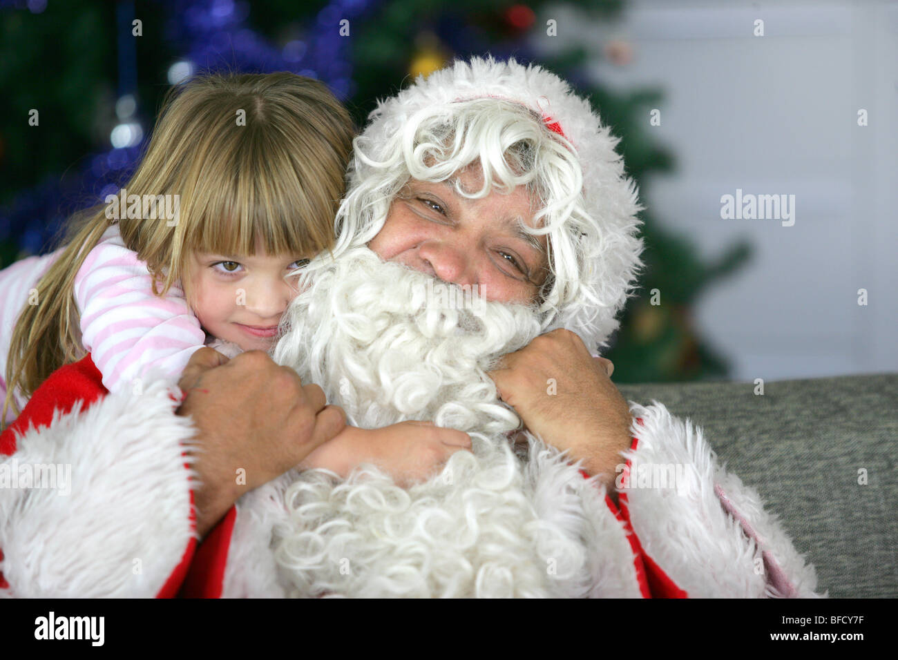 Girl hugging Santa Claus Stock Photo - Alamy