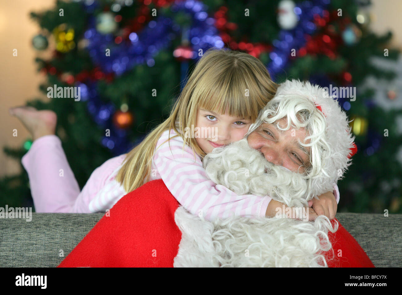 Girl hugging Santa Claus Stock Photo - Alamy