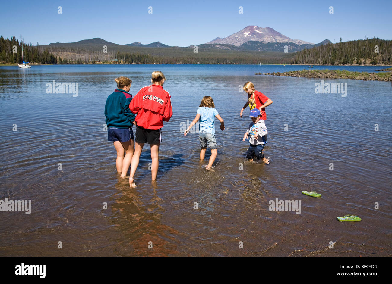 Children on a family outing hunt for crawdads in Elk Lake in the Oregon ...