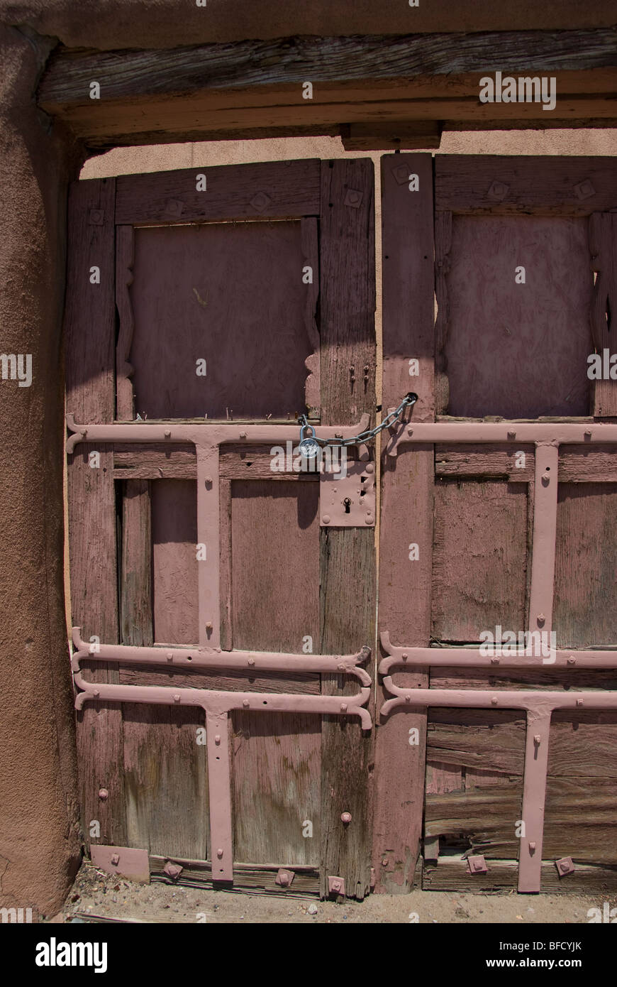 A door locked with a chain and lock padlock on an adobe frame Stock ...