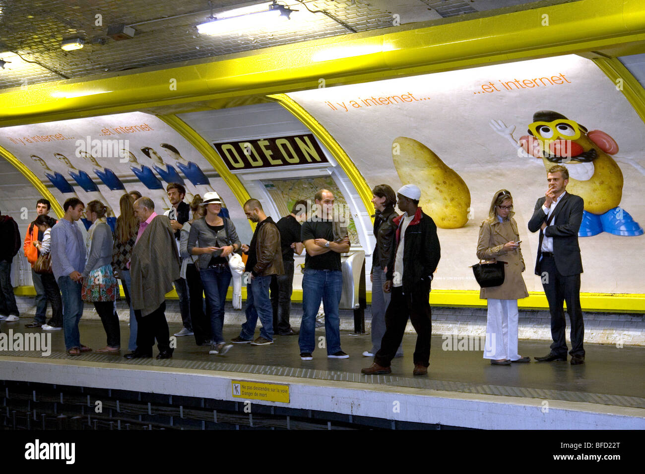 People wait underground on the platform of the Odeon Paris Metro ...