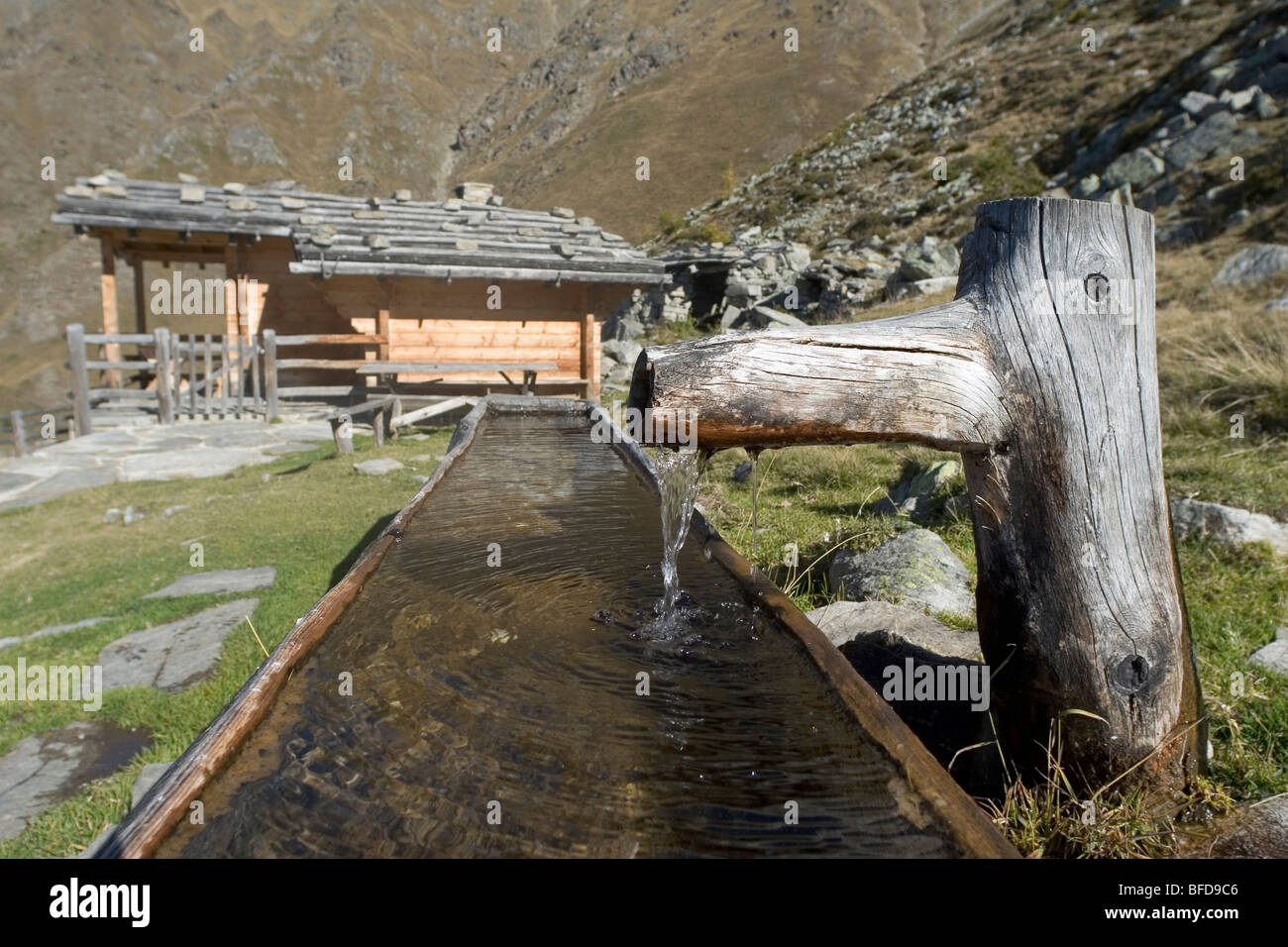 Fresh mountain spring water at hut, traditional fountain and trough for ...
