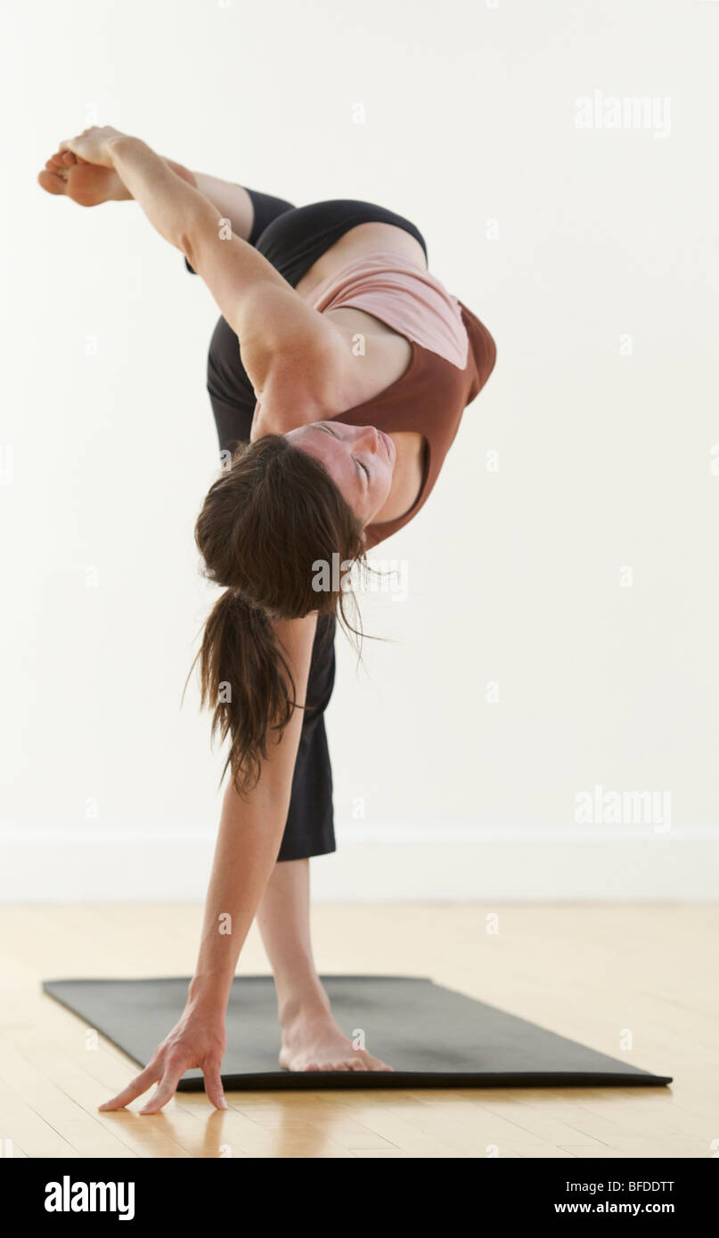 A woman practices yoga in a studio Stock Photo - Alamy