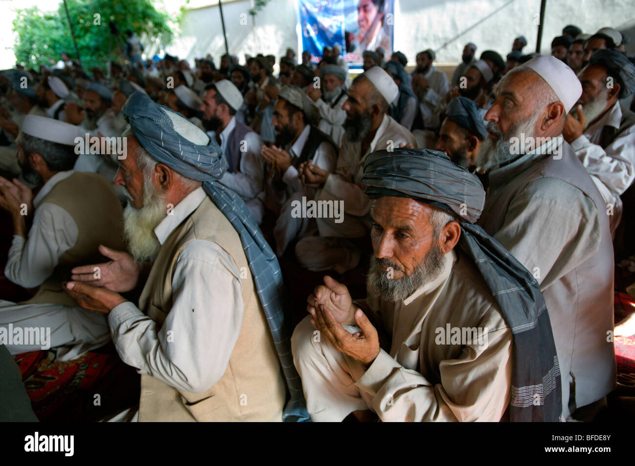 Elder Pashtun leaders cup their hands in prayer at a meeting where they ...