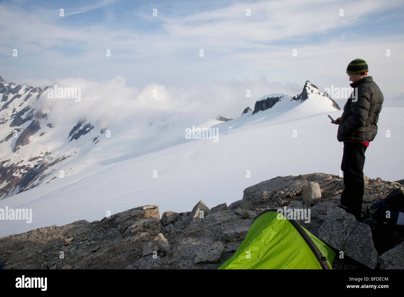 Young climber checks his cell phone for coverage while standing on a ...