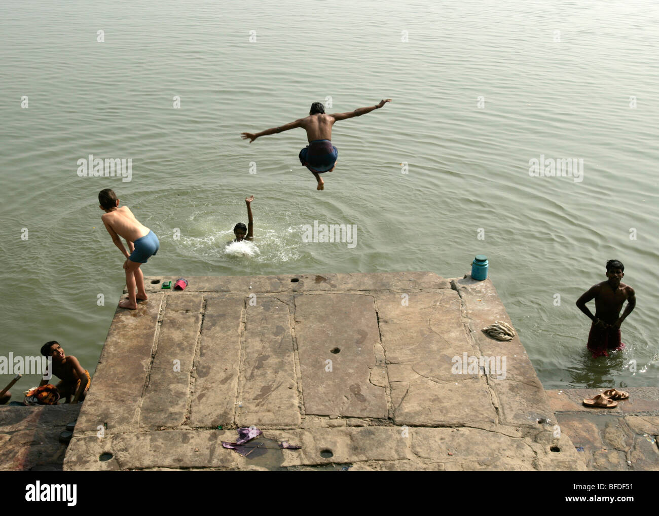 A boy dives into the river in the holy city of Varanasi (Benares) along ...
