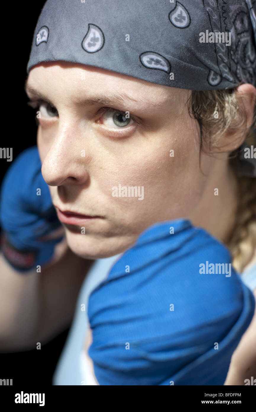 Close-up portrait of female boxer with hands wrapped in tape in ...