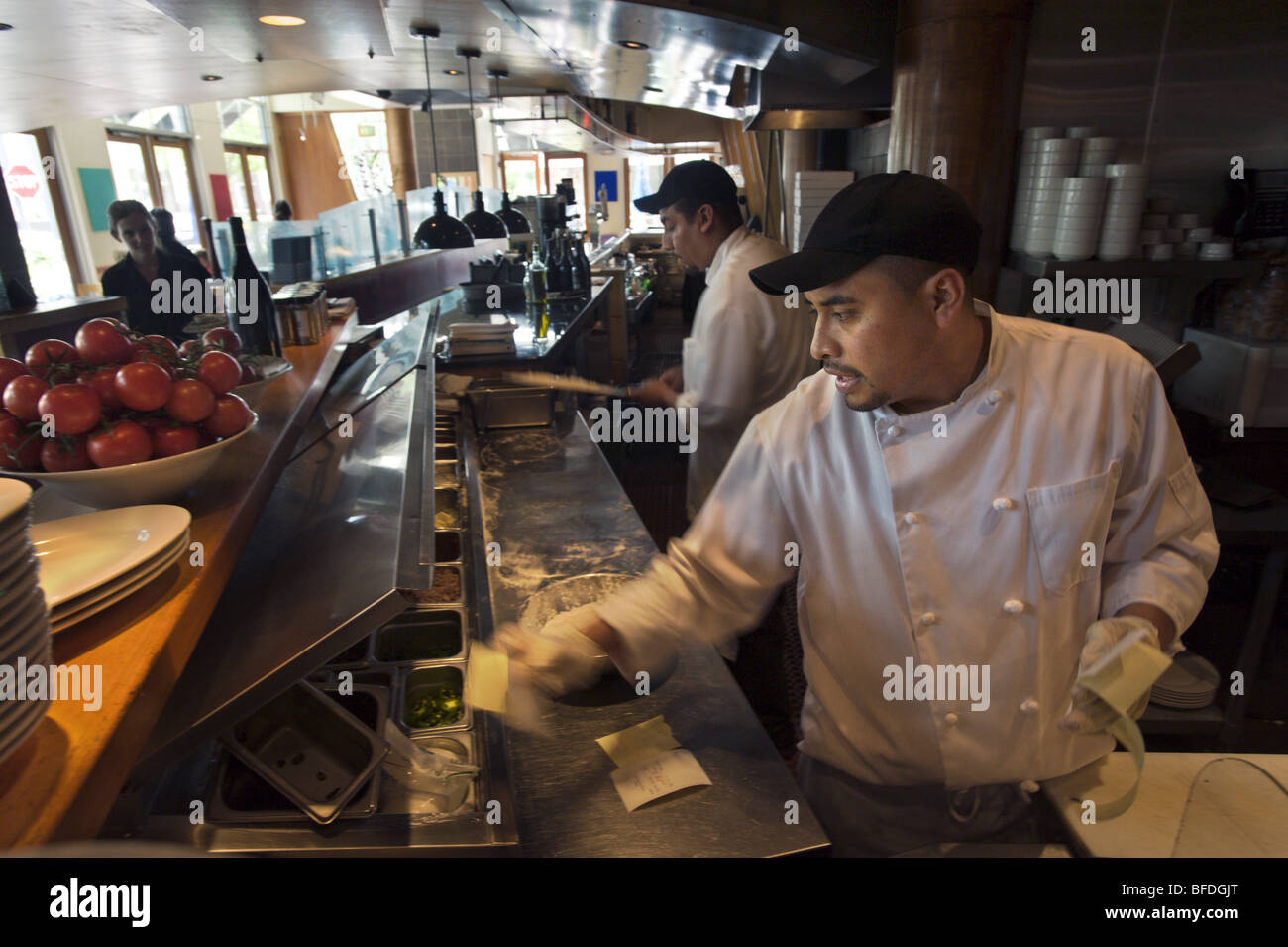A hispanic worker works as a cook at an upscale Italian restaurant ...