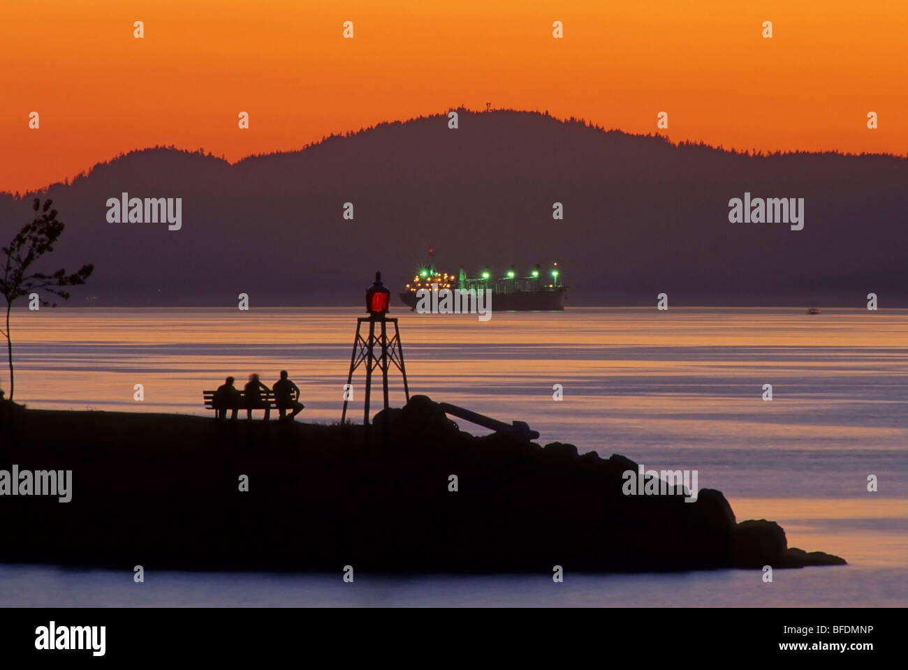 Silhouette of people on bench viewing sunset, Burrard Inlet, Vancouver ...