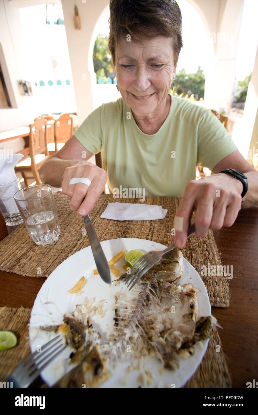 Close-up of woman eating remnants of whole fish - Shela Village - Lamu ...