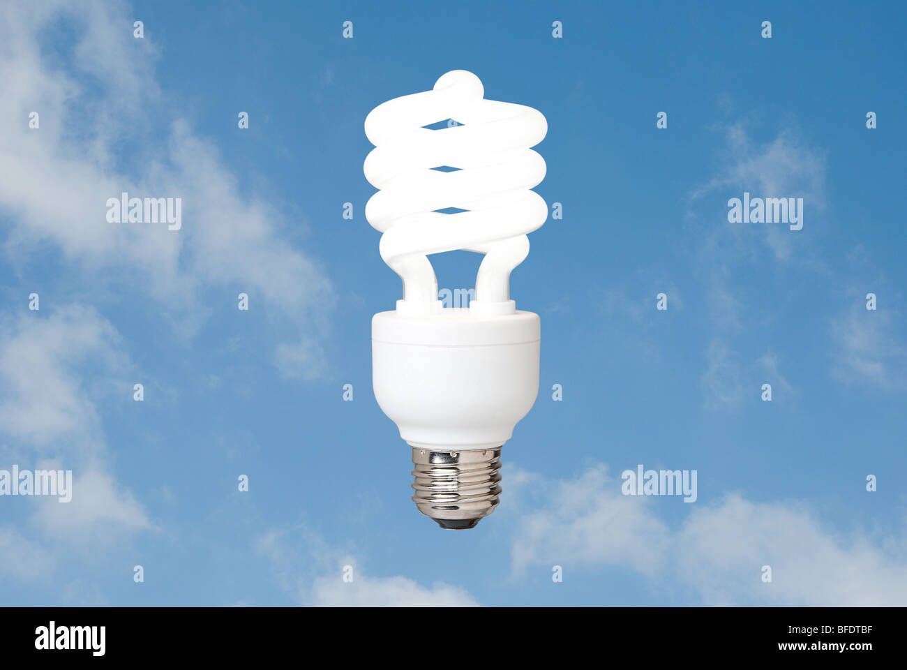 a compact fluorescent light bulb against a blue sky with clouds Stock ...