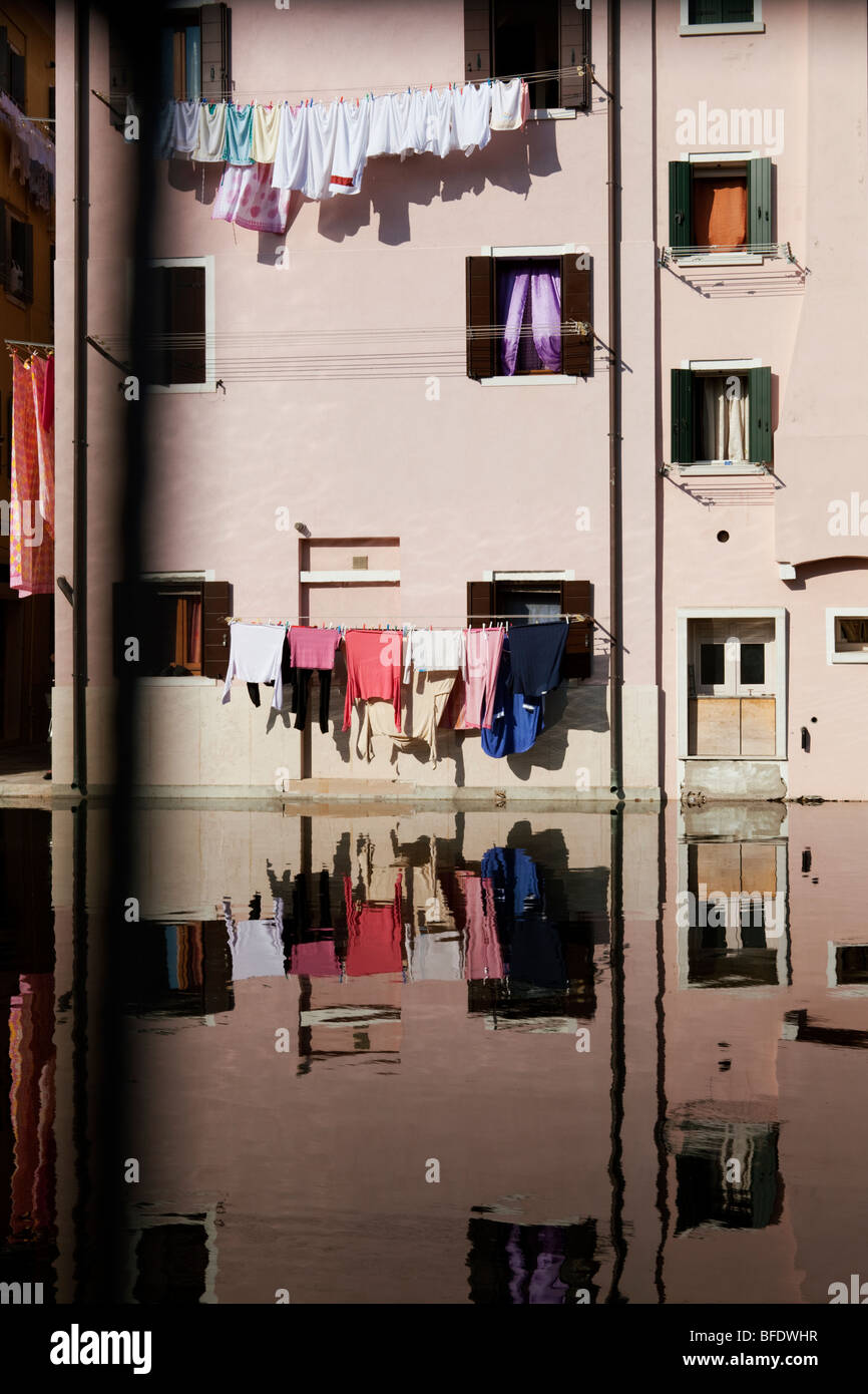 LAUNDRY DRYING OUT OF A HOUSE ON A CLOTHESLINE WITH REFLECTION IN THE ...