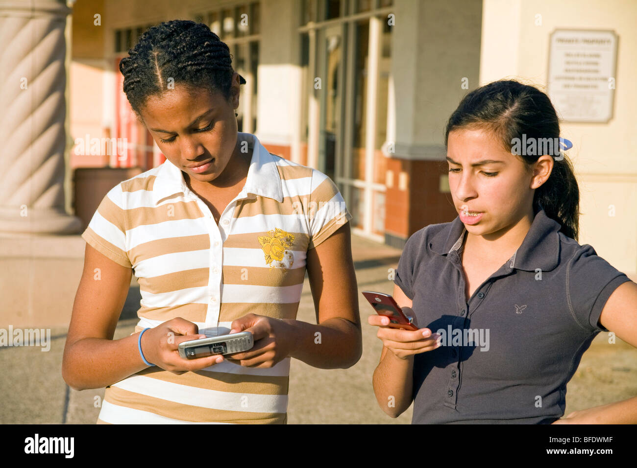 Hang hanging out African American and Hispanic teen girls texting on ...