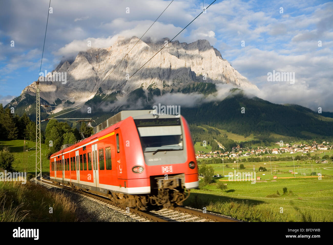 A train rolls through meadows below Zugspitze Stock Photo - Alamy