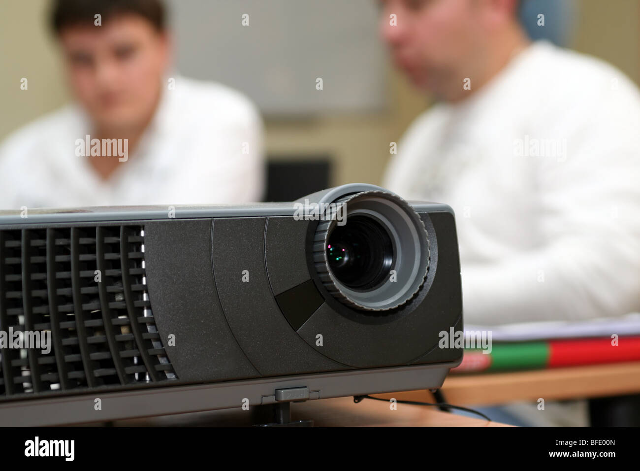 Projector at office table with person behind Stock Photo - Alamy
