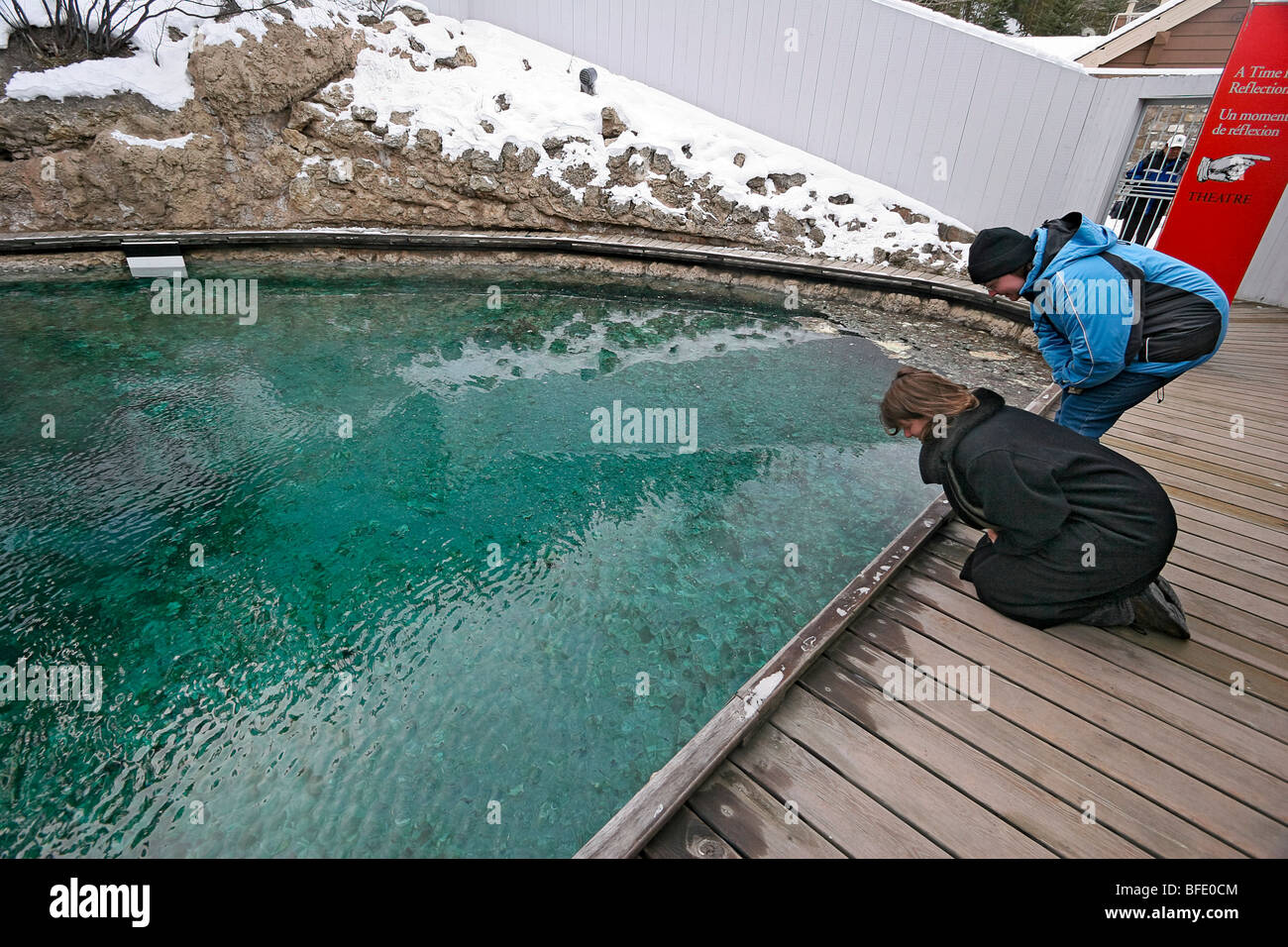 Visitors look at endangered snails in pool at Cave and Basin, Banff's ...