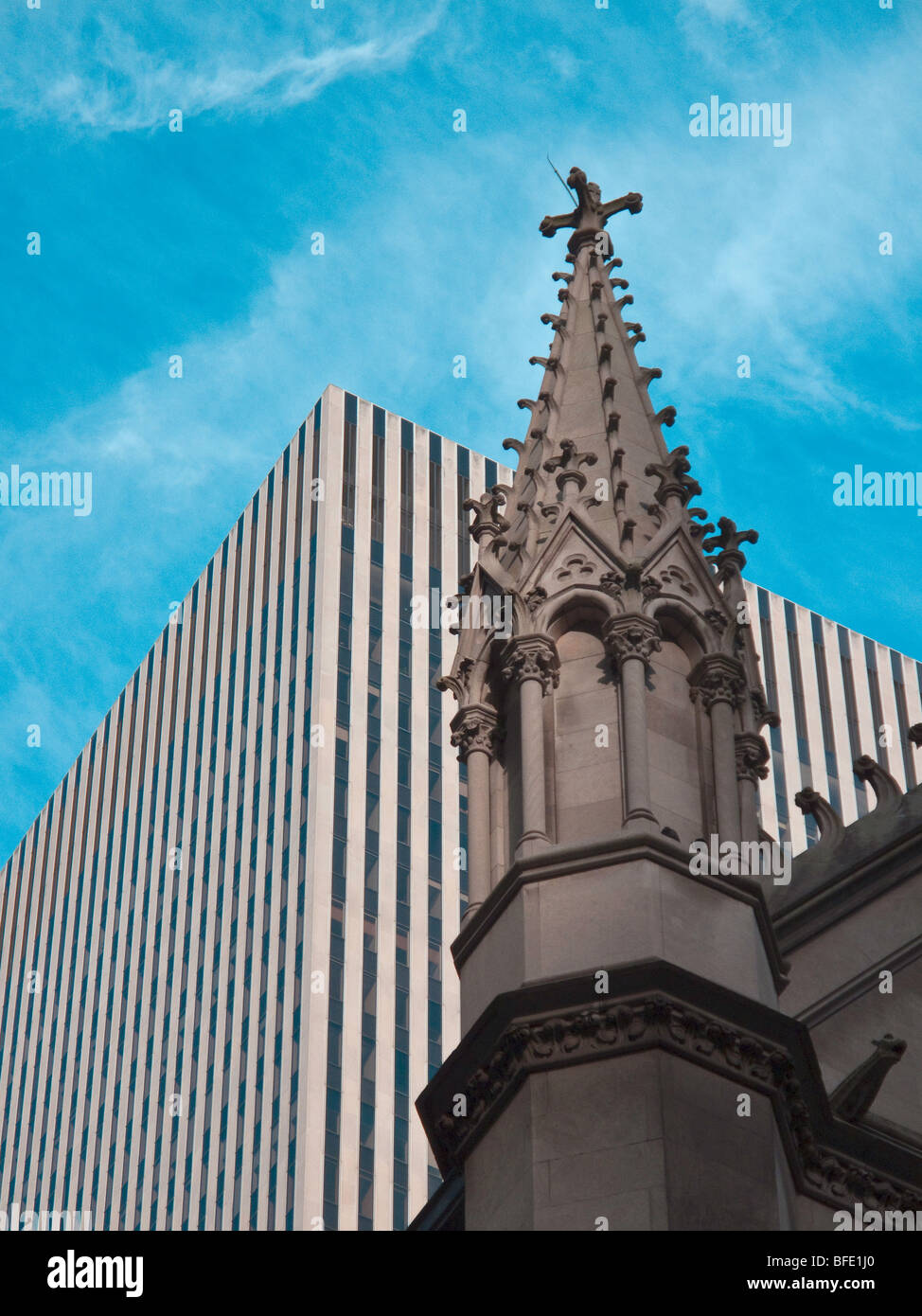 Ornate church spire is juxtaposed with the vertical lines of a modern ...