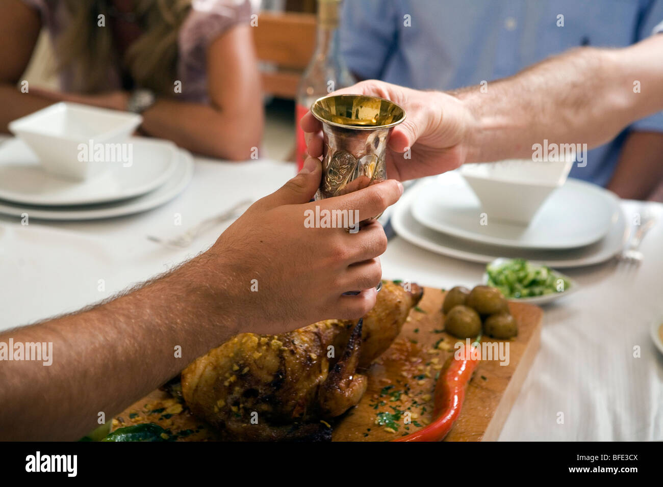 Man passing the blessed wine at a festive dinner table Stock Photo - Alamy