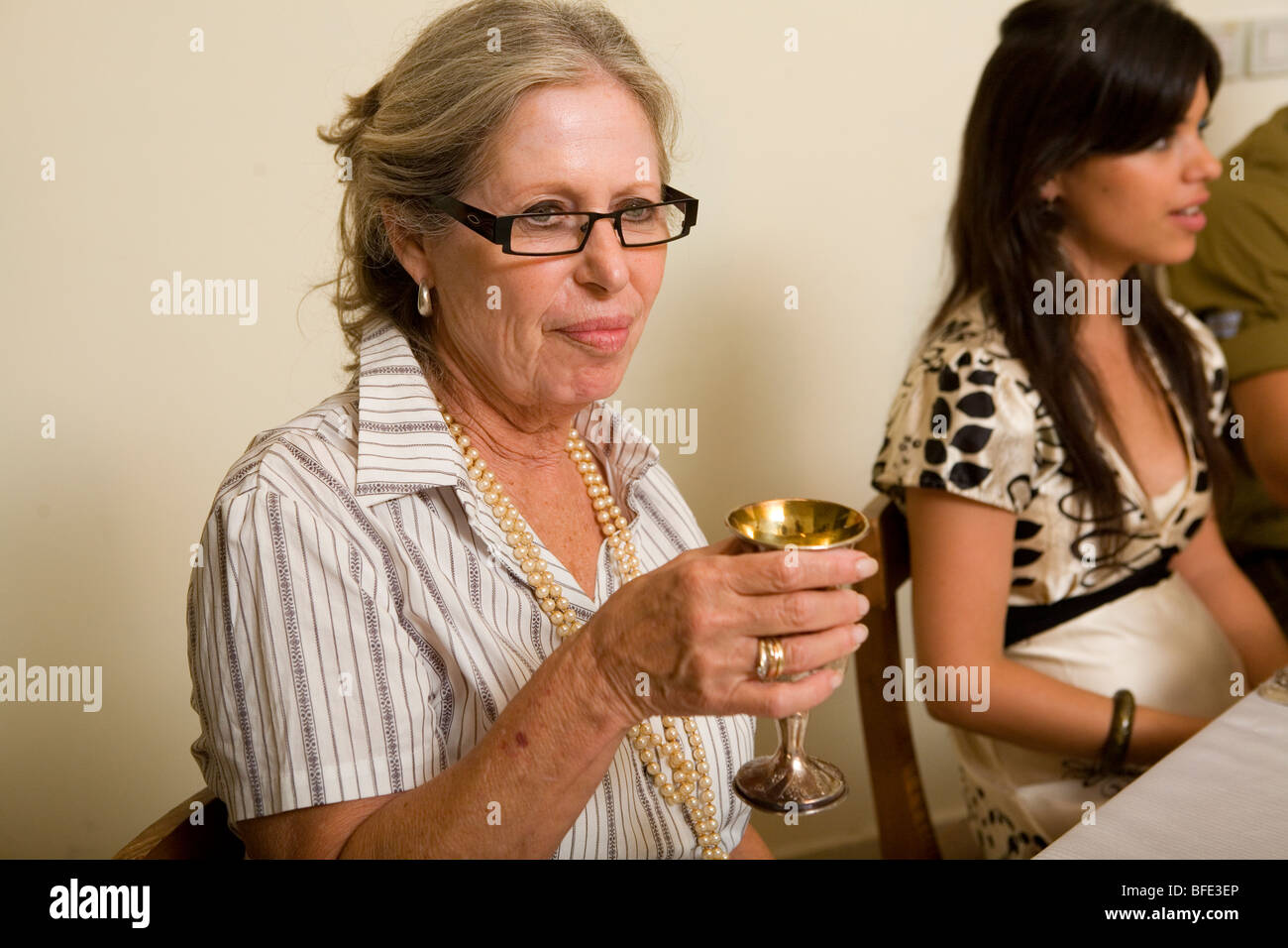 Elder woman drinking blessed wine Stock Photo - Alamy