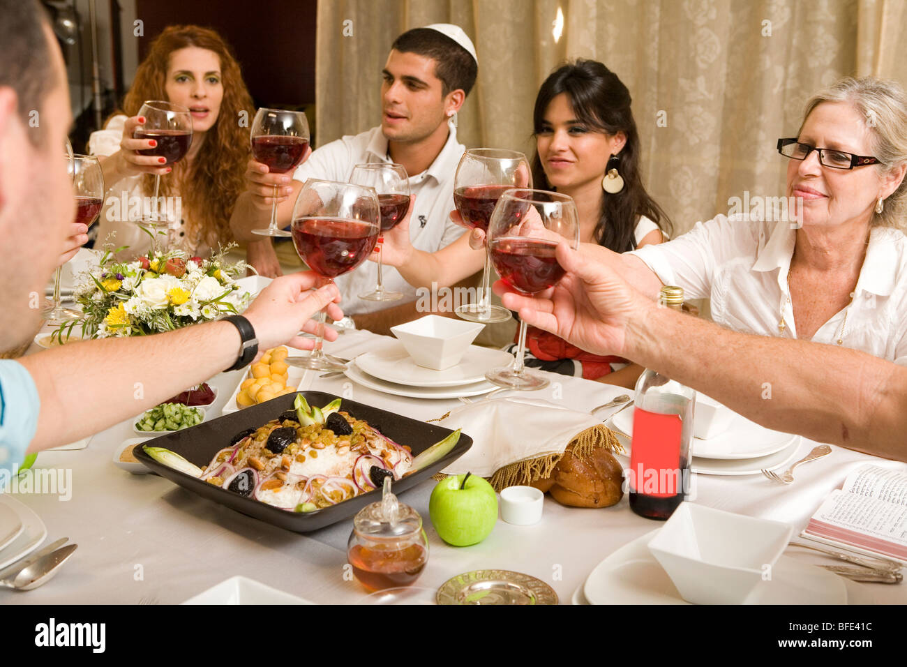 Family at a festive dinner table (Cheers Stock Photo - Alamy