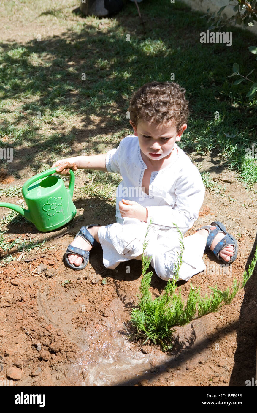 Boy caring for his newly planted tree Stock Photo - Alamy