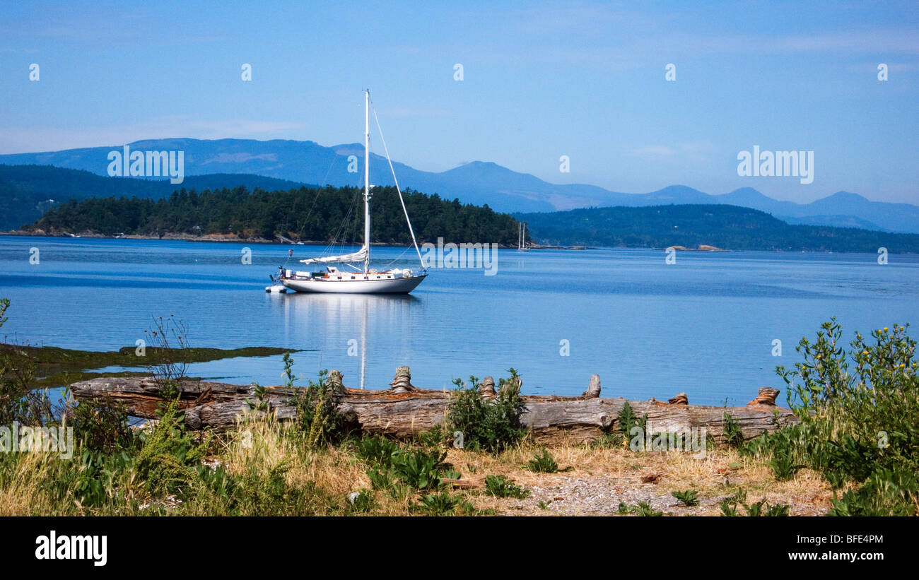 A boat lies at anchor in Montague Harbour Provincial Marine Park on ...