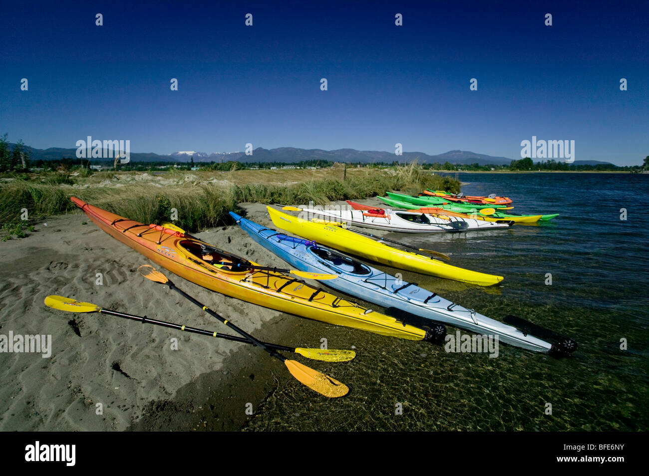 Bright and colorful kayaks hauled up in the Comox Bay, Comox Valley ...