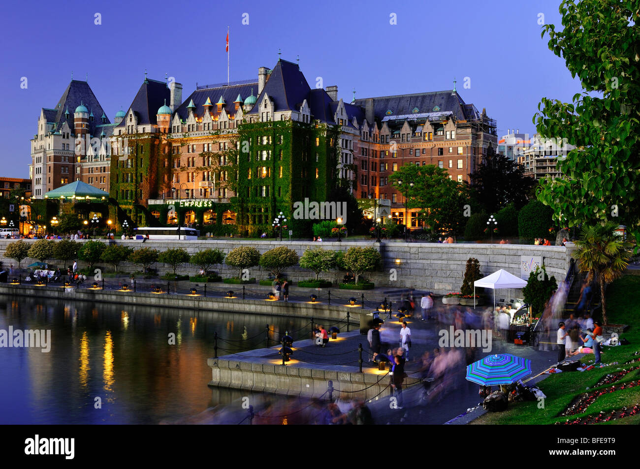 Empress Hotel at dusk with waterfront causeway activity, Victoria ...