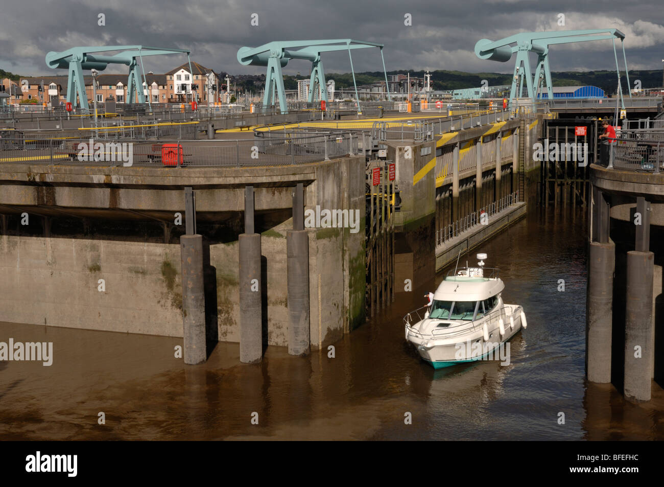 Cabin cruiser exiting tidal lock, Cardiff Bay Barrage, Cardiff, Wales ...