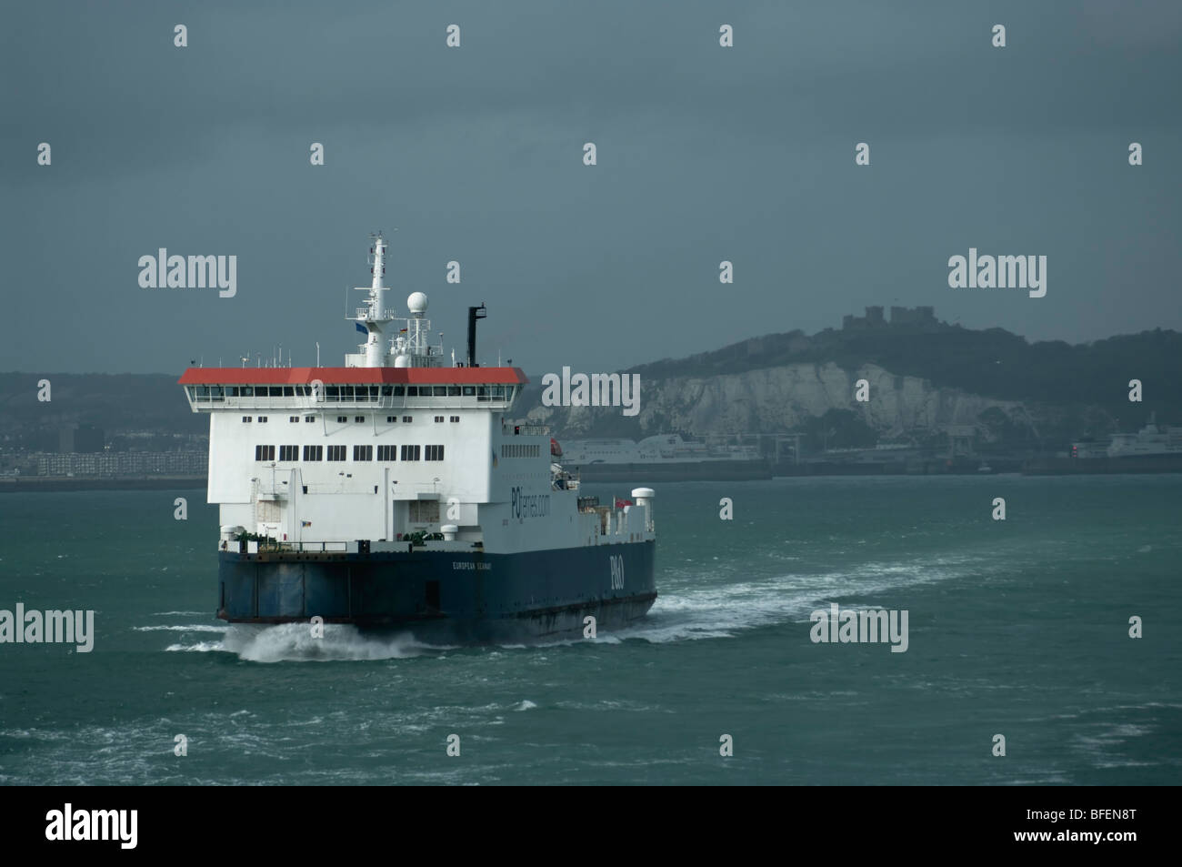 cargo ship leaves dover harbour with dover castle and white cliffs in ...