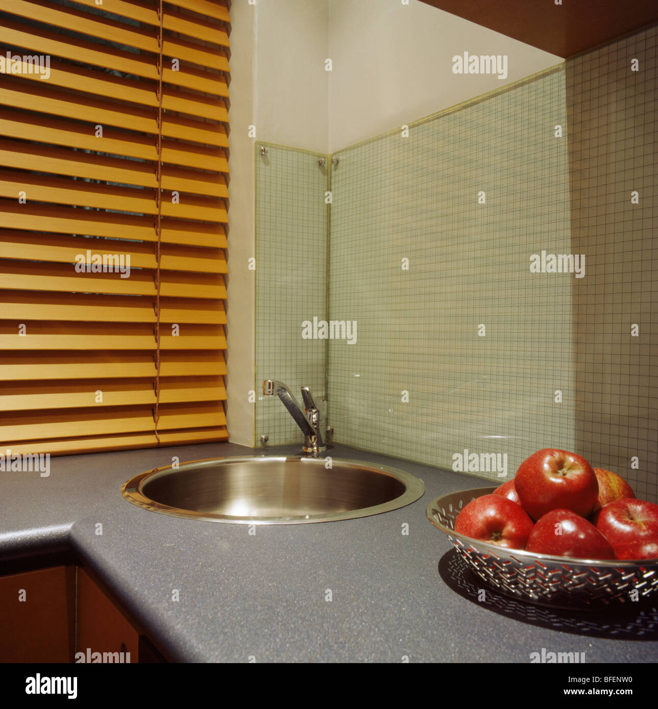 Close-up of circular stainless-steel corner in grey granite worktop ...