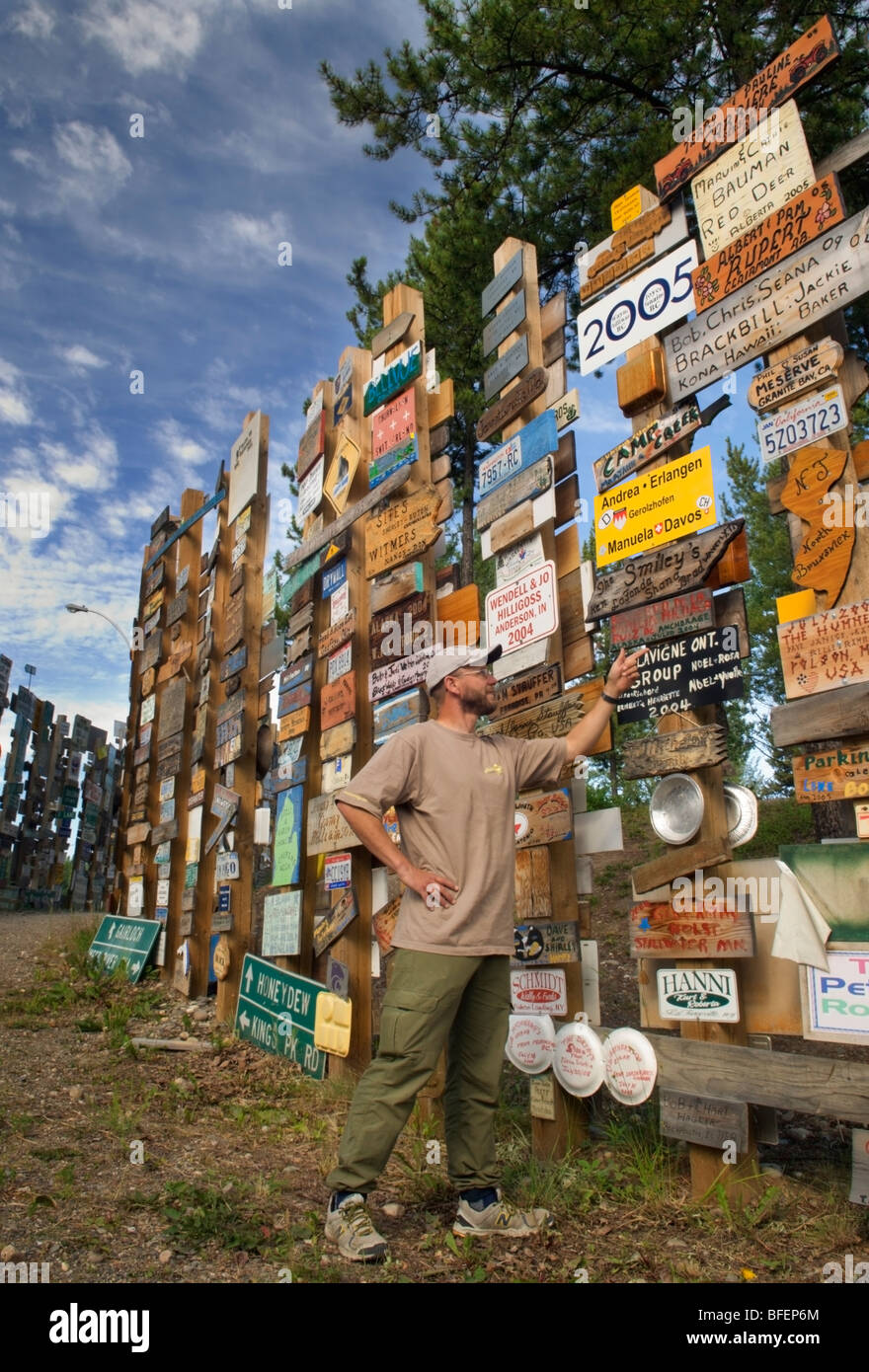 Caucasian male looking at Sign Post Forest, Watson Lake, Yukon ...