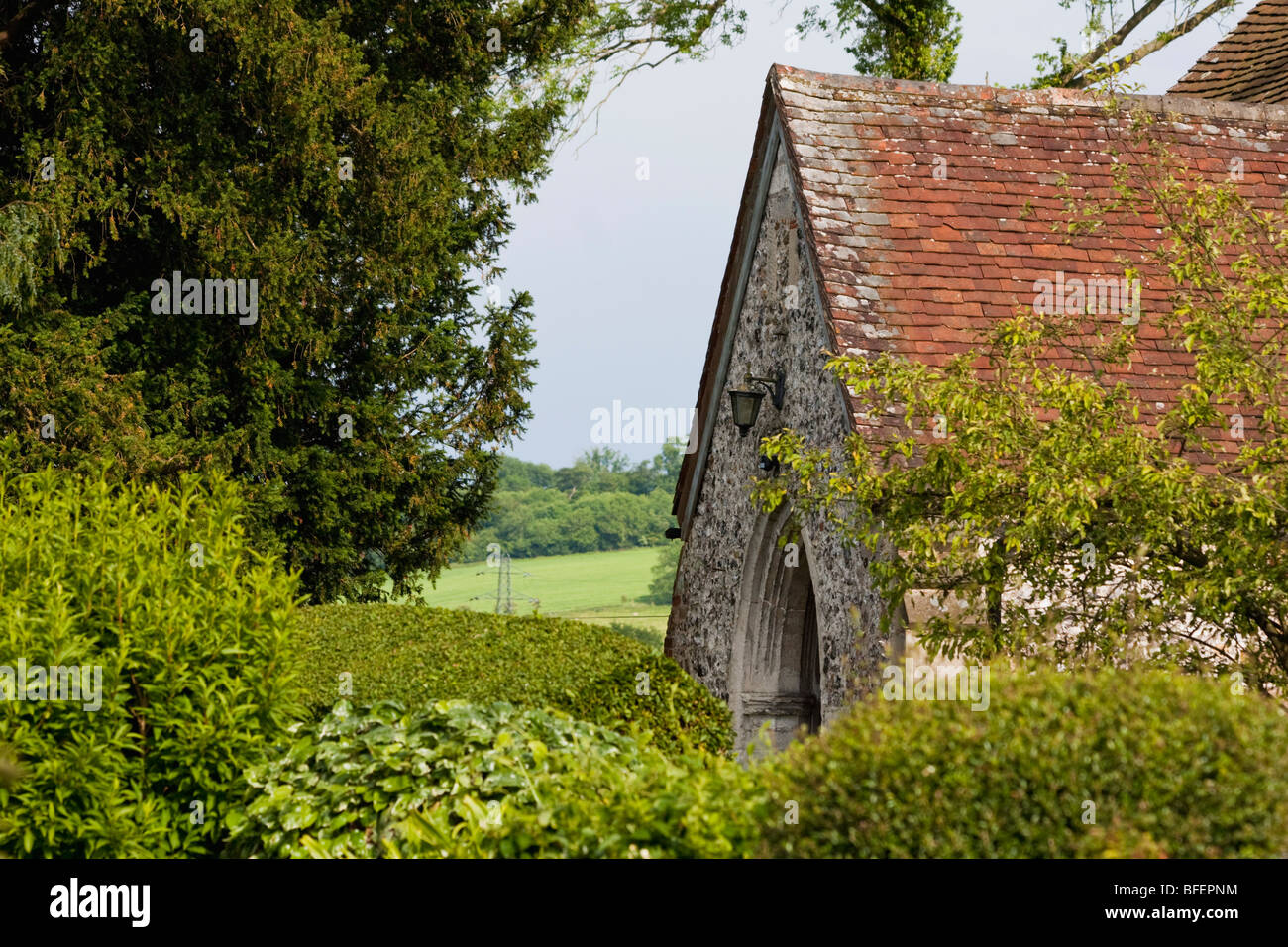 Church porch seen through summer undergrowth in Sussex, england Stock ...