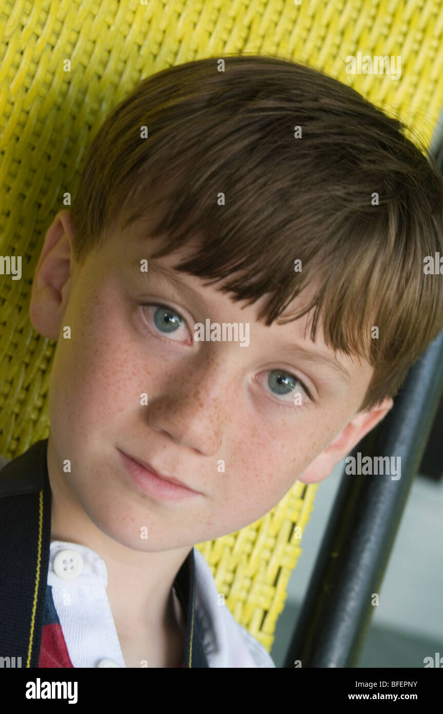 Freckle faced young boy on yellow rocking chair blue eyes Stock Photo ...